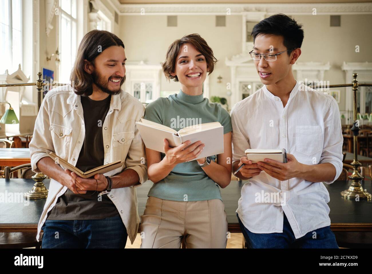 Group of young casual multinational students joyfully studying with ...