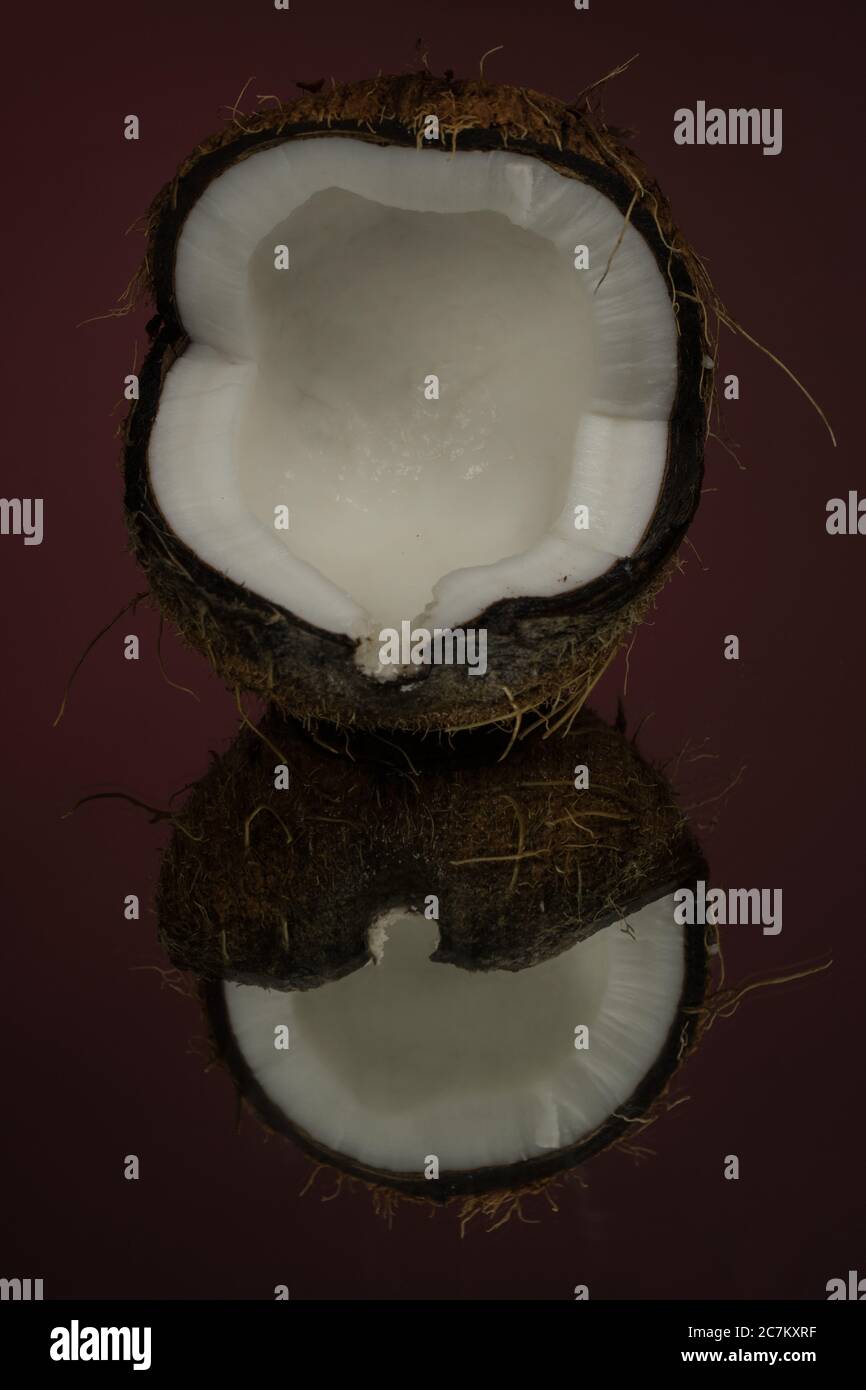 Coconut on a red background. Dark background Stock Photo - Alamy