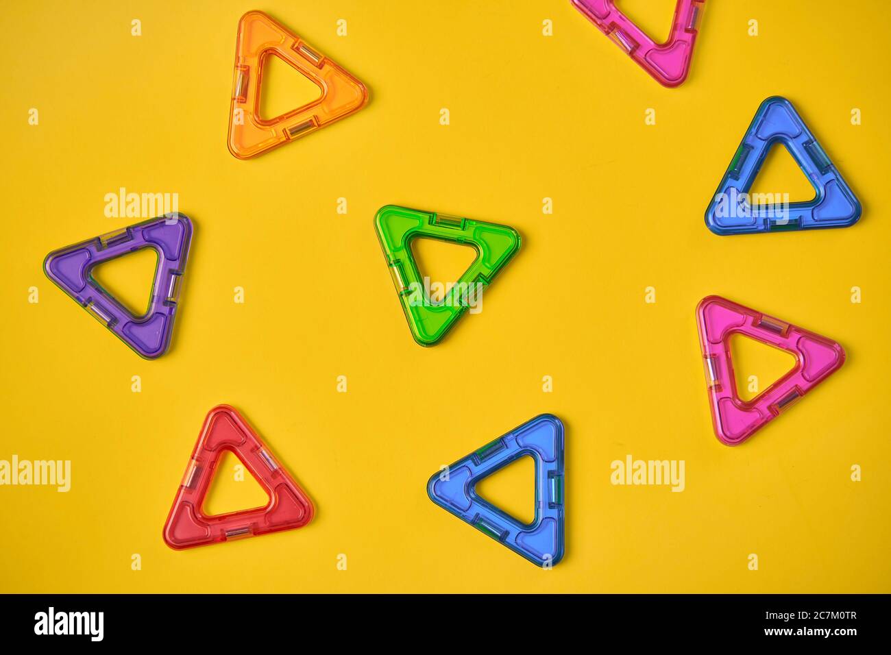 Top view of colorful magnetic building blocks on yellow background ...