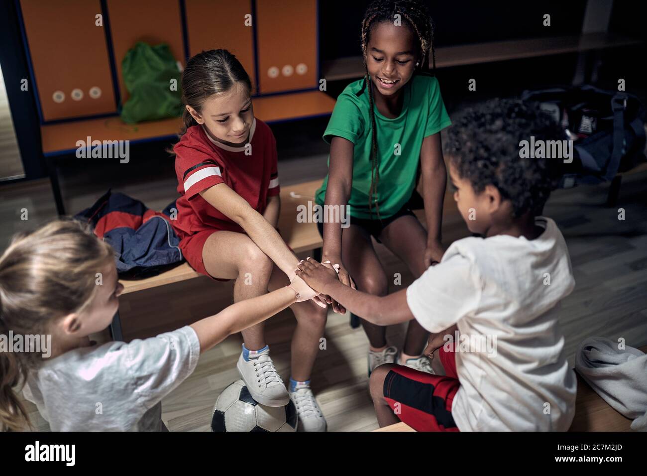 Team of kids team doing high five before match or training Stock Photo ...