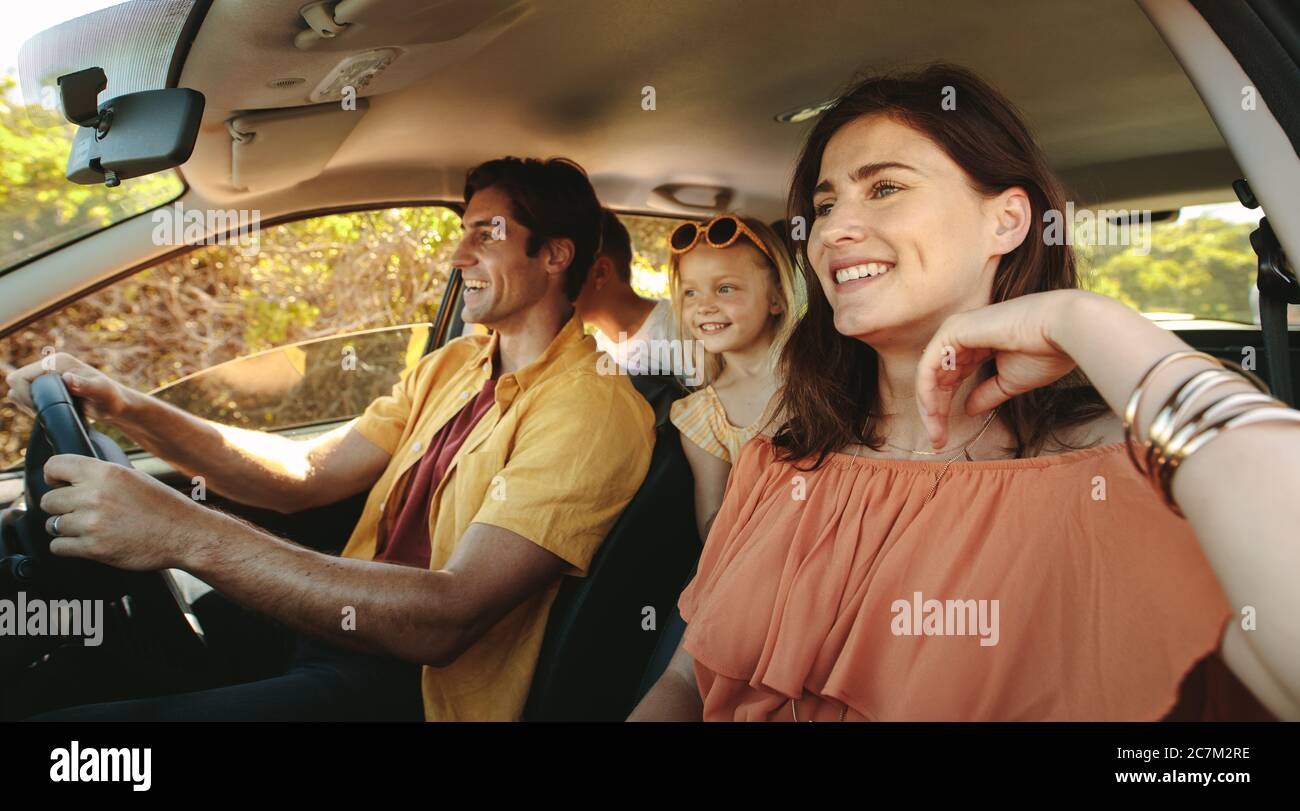 Family driving in a car on countryside road trip. Family with two ...