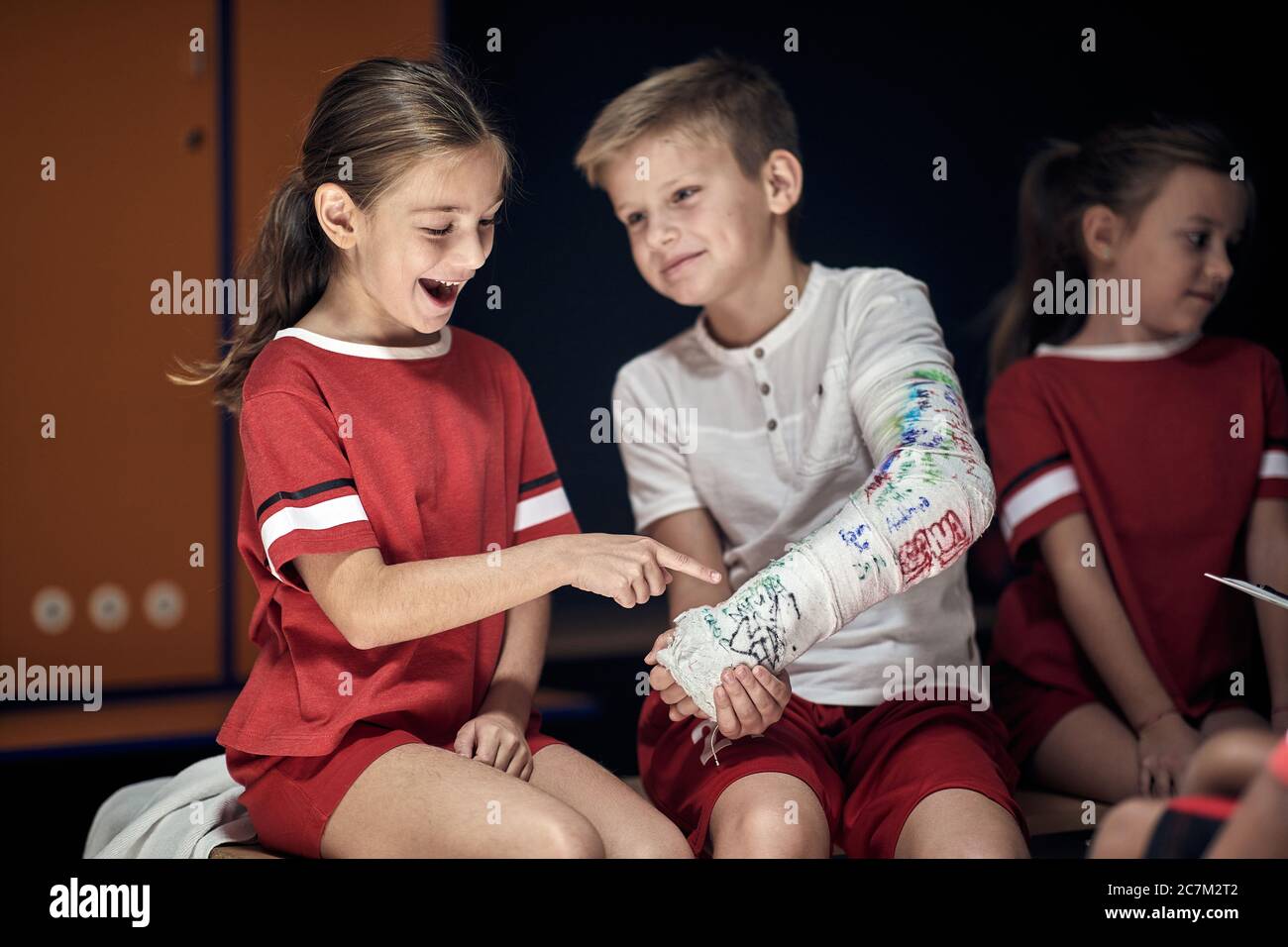 Young boy with broken arm wrapped medical cast plaster in locker room ...