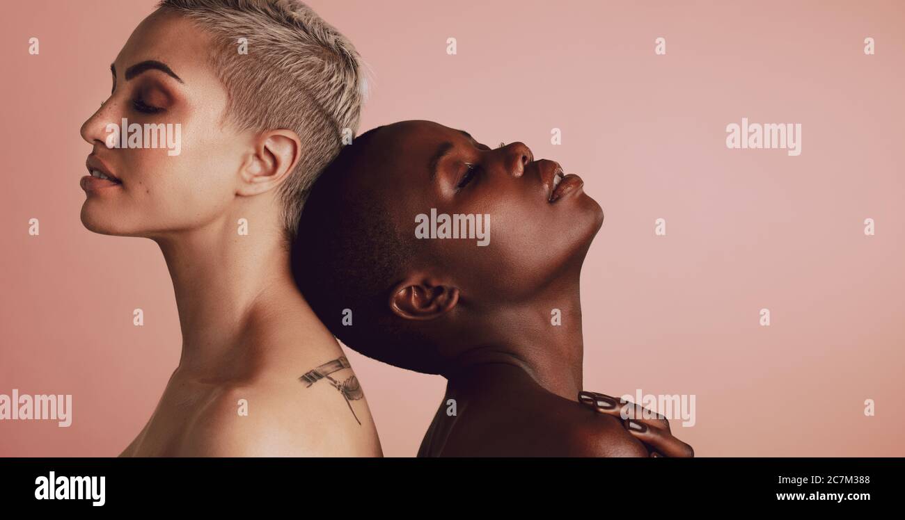 Diverse female models standing back to back and with their eyes closed ...