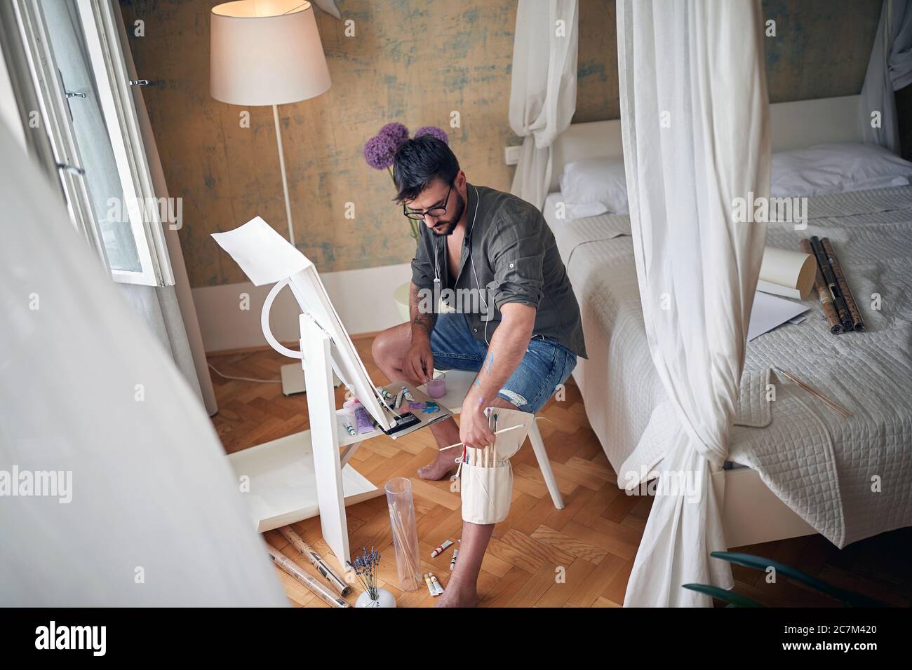 Young handsome painter painting in his bedroom Stock Photo - Alamy