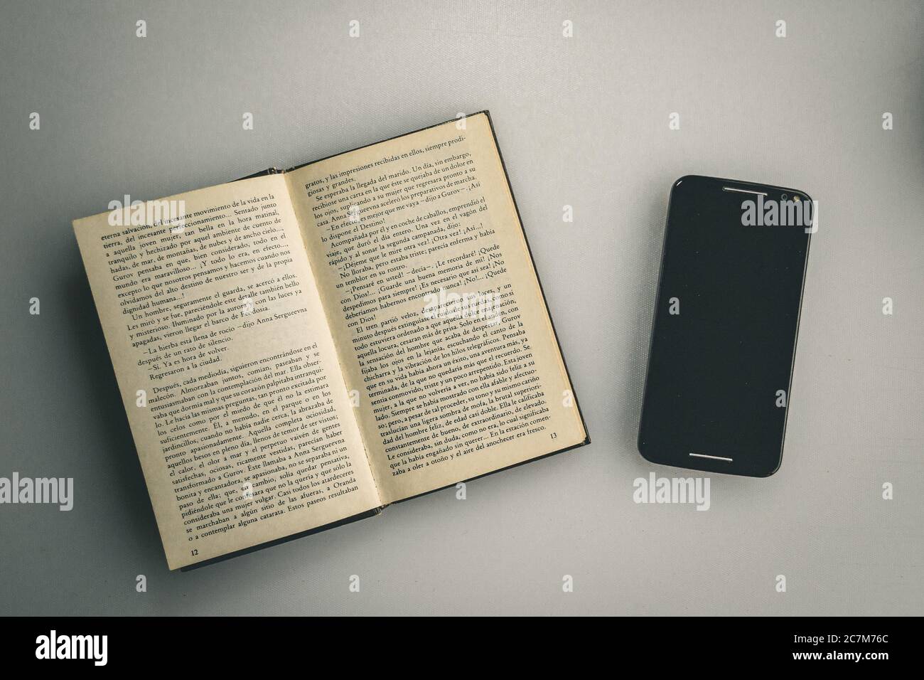 Overhead shot of an open book next to a phone Stock Photo - Alamy
