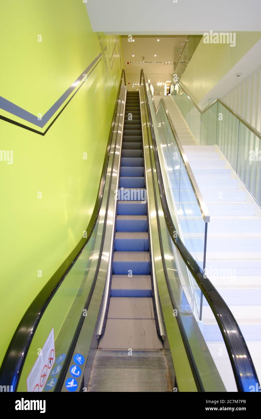 Vertical shot of an escalator and stairs on the side Stock Photo - Alamy