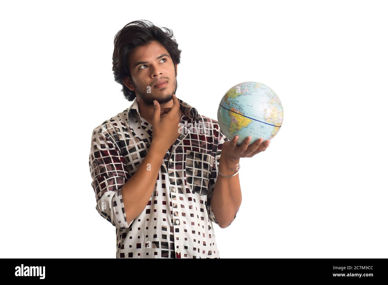 young man with a world globe on a white background Stock Photo - Alamy