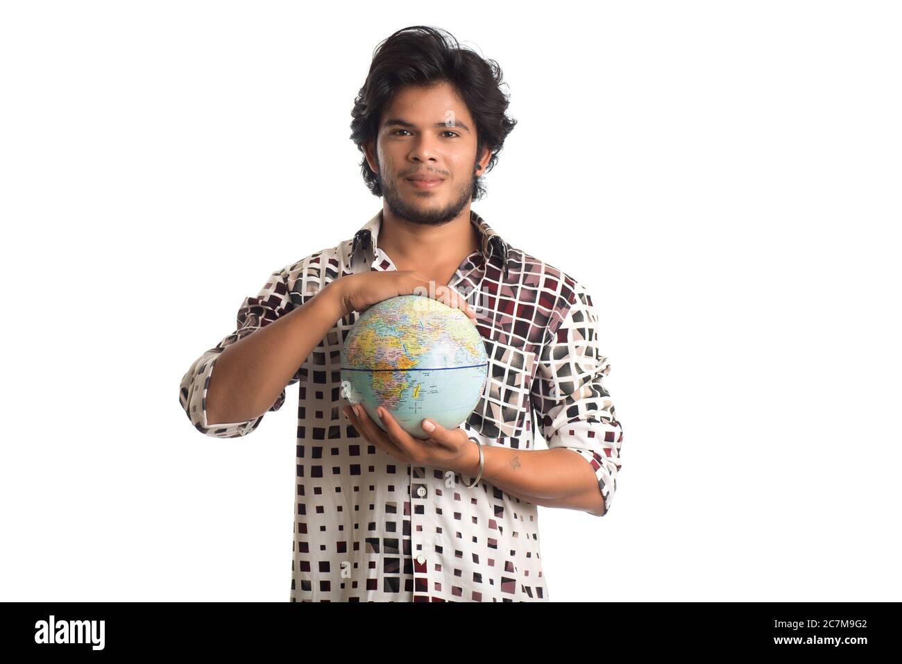 young man with a world globe on a white background Stock Photo - Alamy