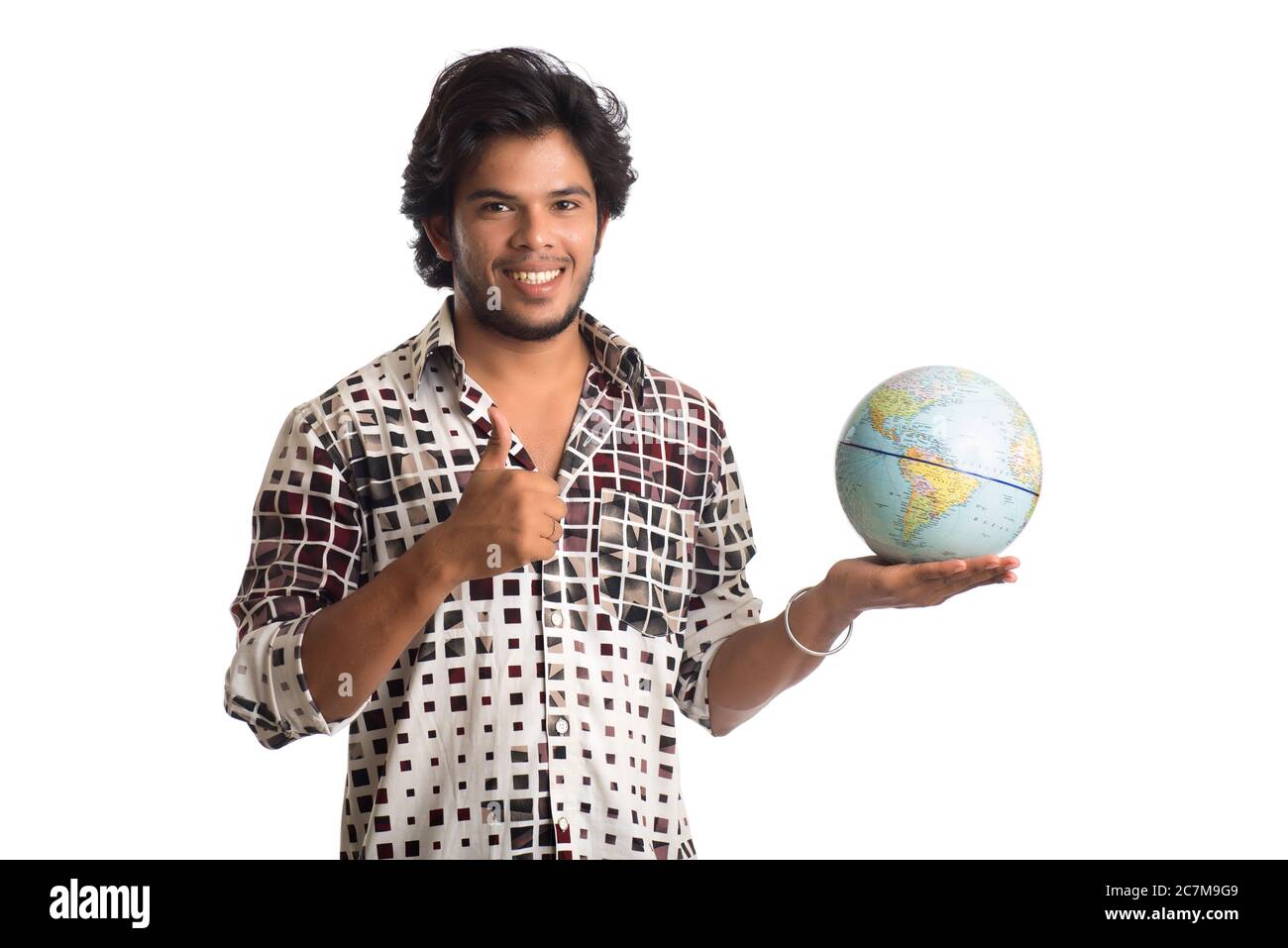 young man with a world globe on a white background Stock Photo - Alamy