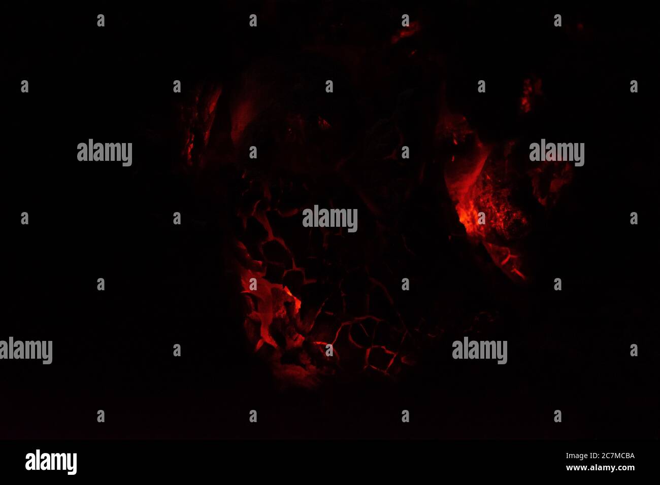 Burning and glowing charcoal close-up. Red coals with fire on a black ...