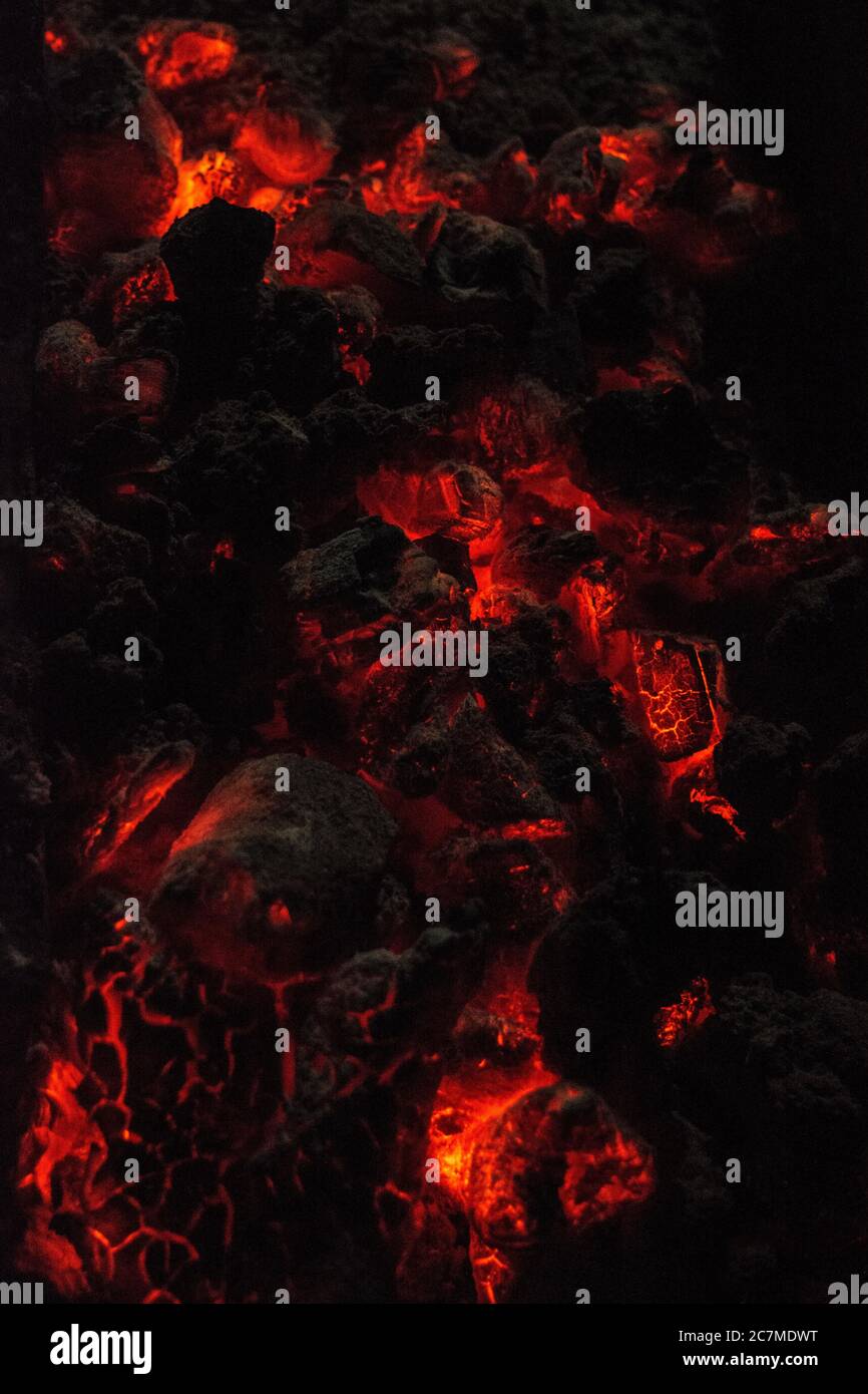 Burning and glowing charcoal close-up. Red coals with fire on a black ...