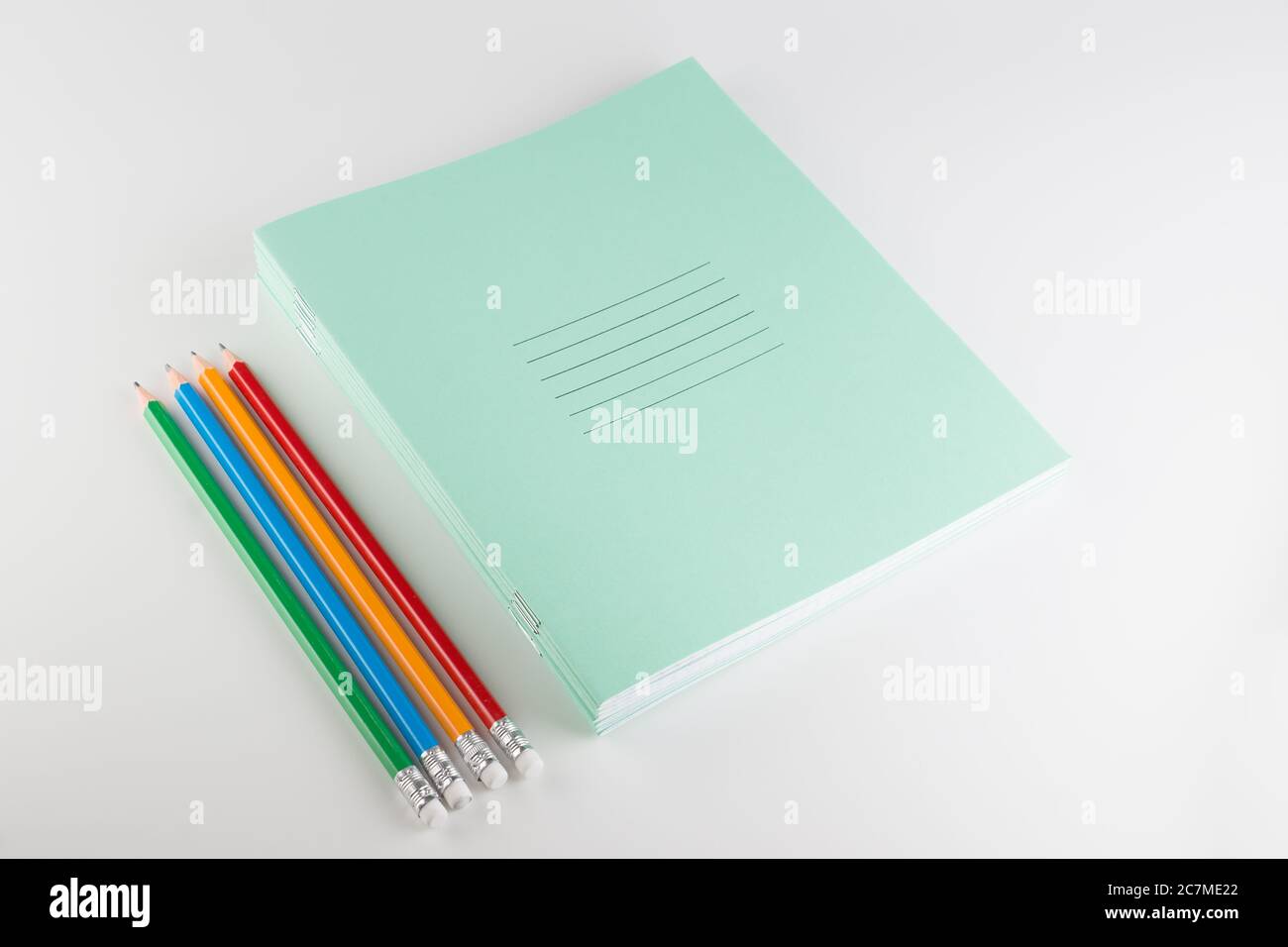stack of thin student notebooks with colored pencils for school Stock ...