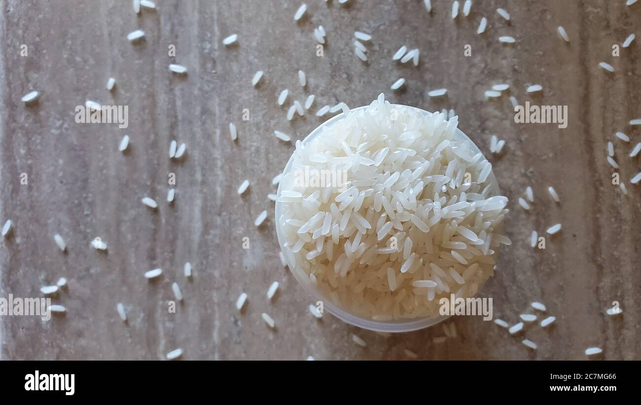 Top view of rice bowl and scattered rice grains atop marble surface of ...