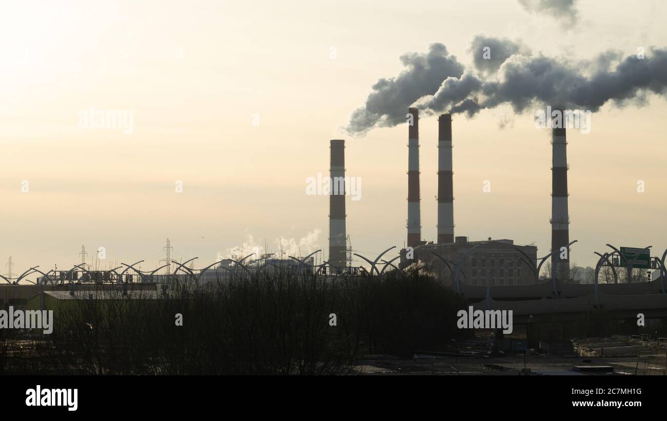 Spring, evening setting sun and smoking plant pipes. Dissonance of pure ...