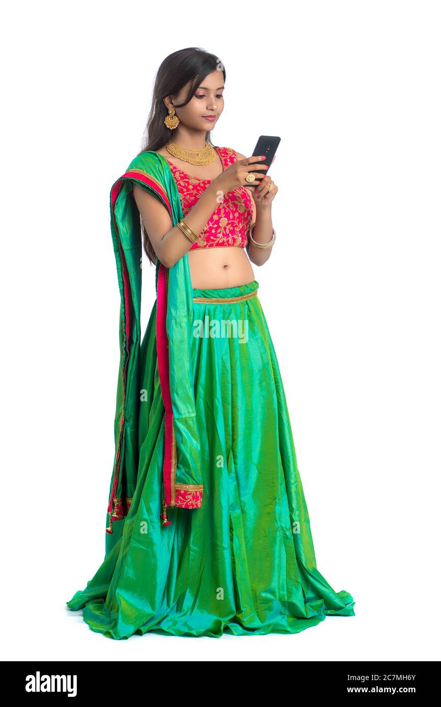 Young Indian traditional girl using a mobile phone or smartphone ...