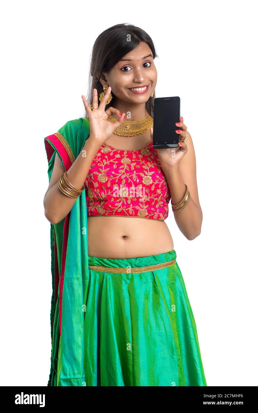 Young Indian traditional girl using a mobile phone or smartphone and ...