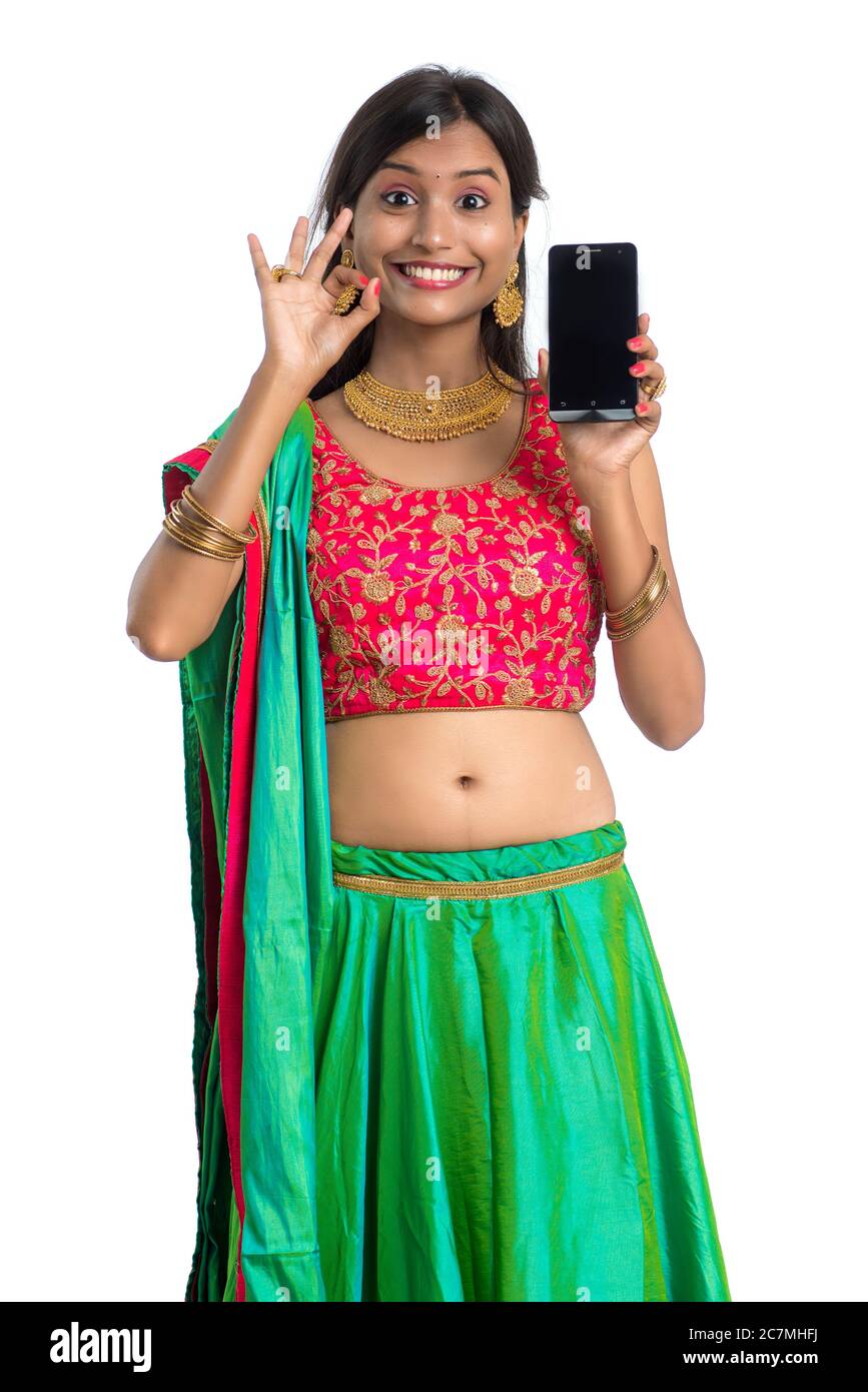 Young Indian traditional girl using a mobile phone or smartphone and ...