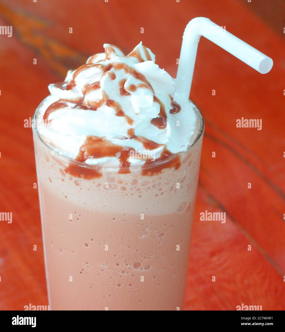 Milk shake with a cream topping and a straw Stock Photo - Alamy