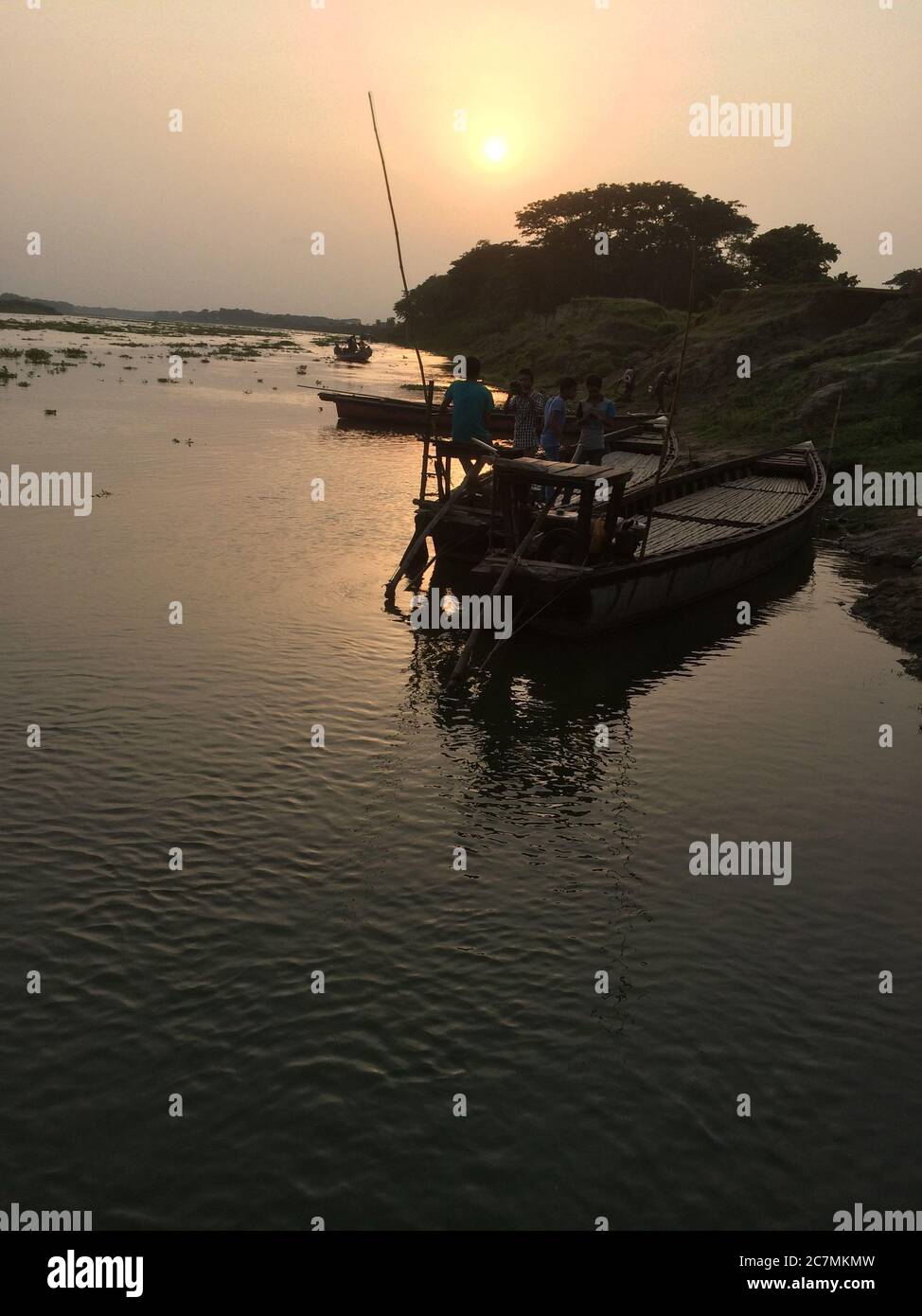 Idling country boats tied to the banks of the river Turag, outside ...