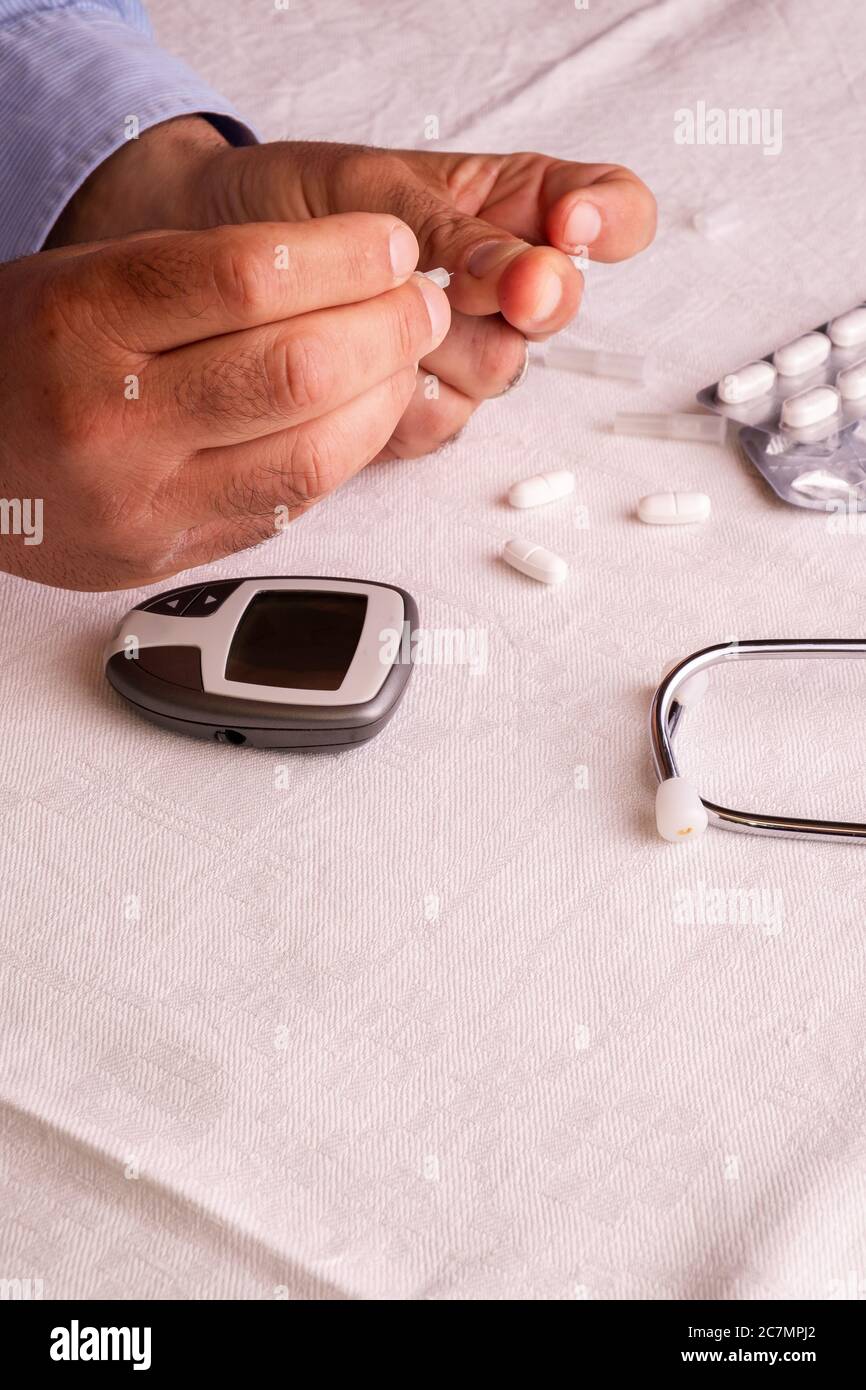 shot of a male hand collecting blood sample for hgt test with tablets ...