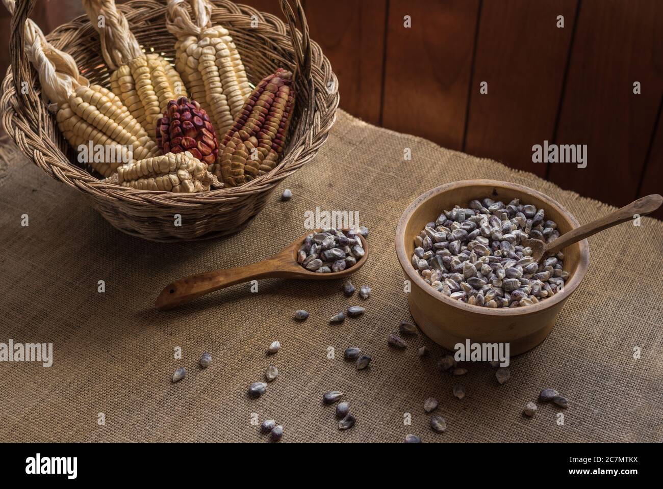 Different types of corns in a basket on the table with dry corn kernels ...