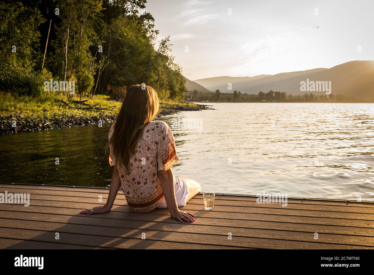 Long Hair woman watching sunset Stock Photo - Alamy