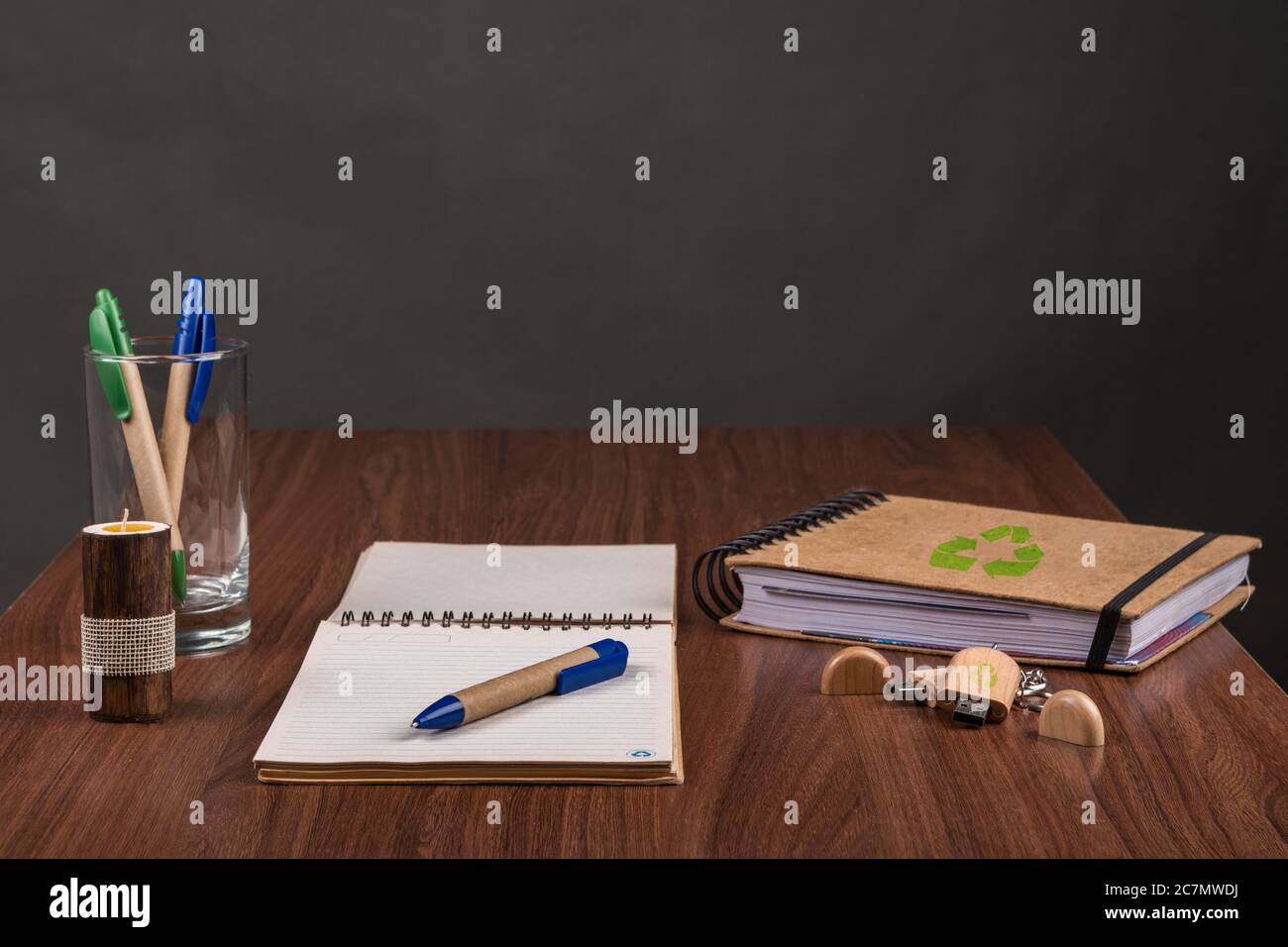Closeup of eco pens and notepads on the table with a USB flash drive ...