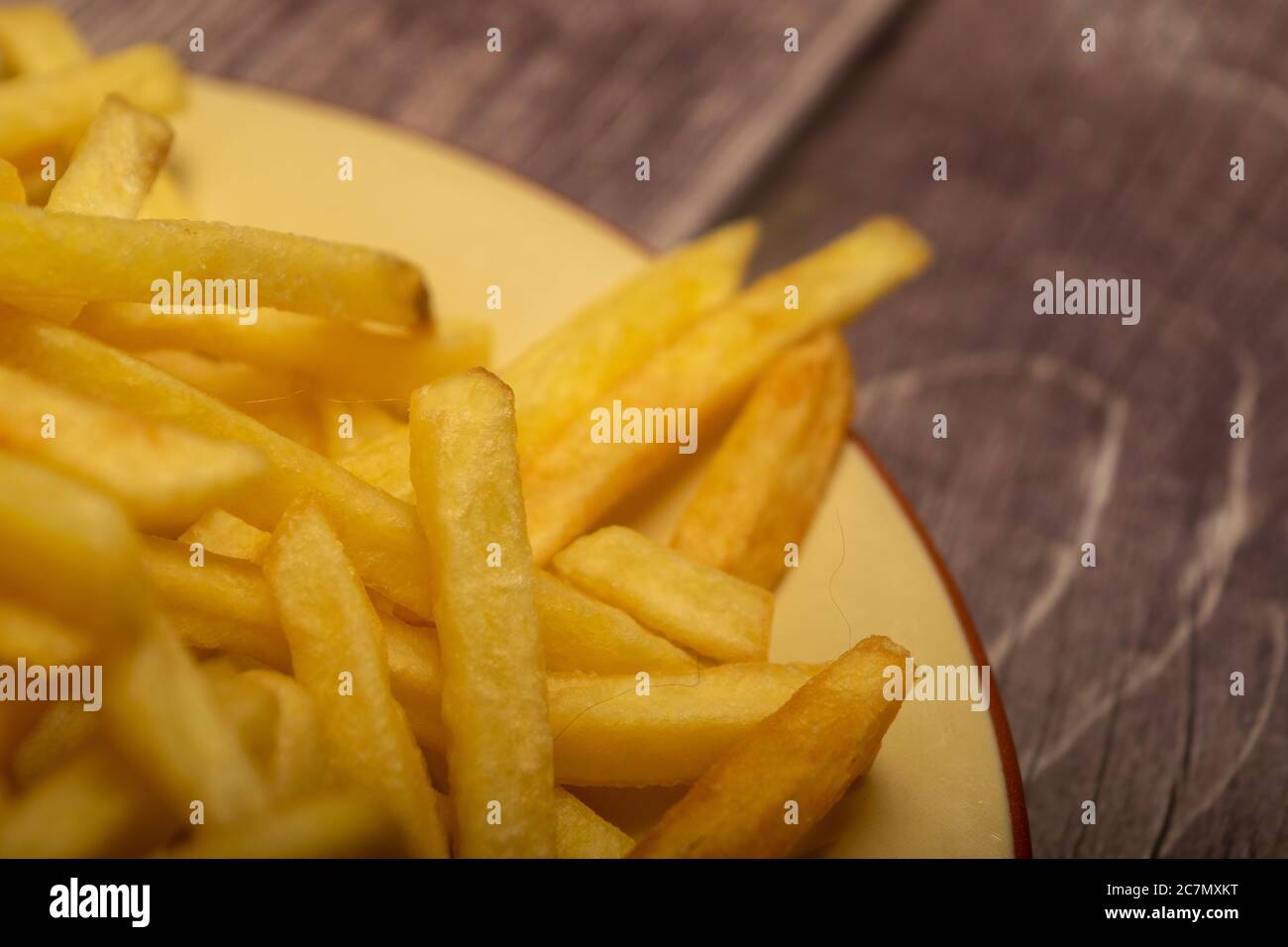 French fries in a round plate on a homespun cloth with a rough texture ...