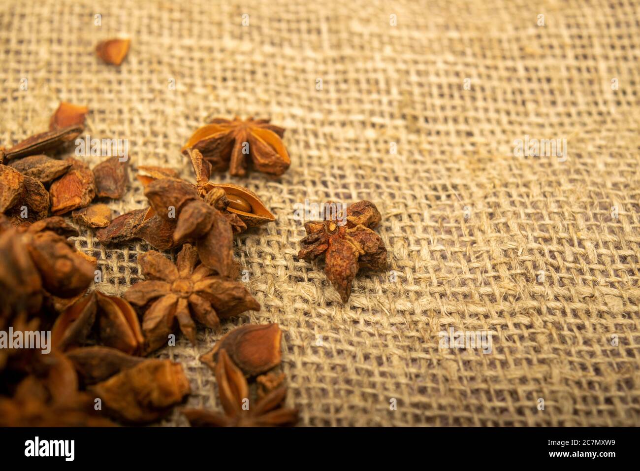 A pile of star anise on a background of burlap with a rough texture ...