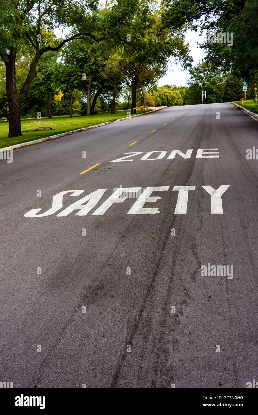 Safety zone stenciled on roadway in large white letters on black ...