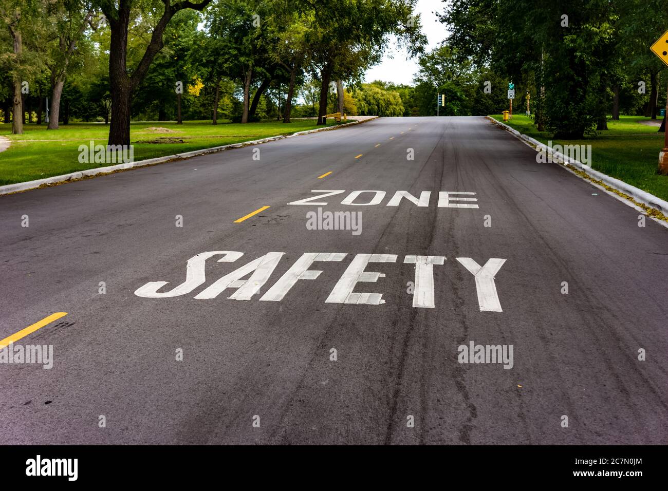 Safety zone stenciled on roadway in large white letters on black ...