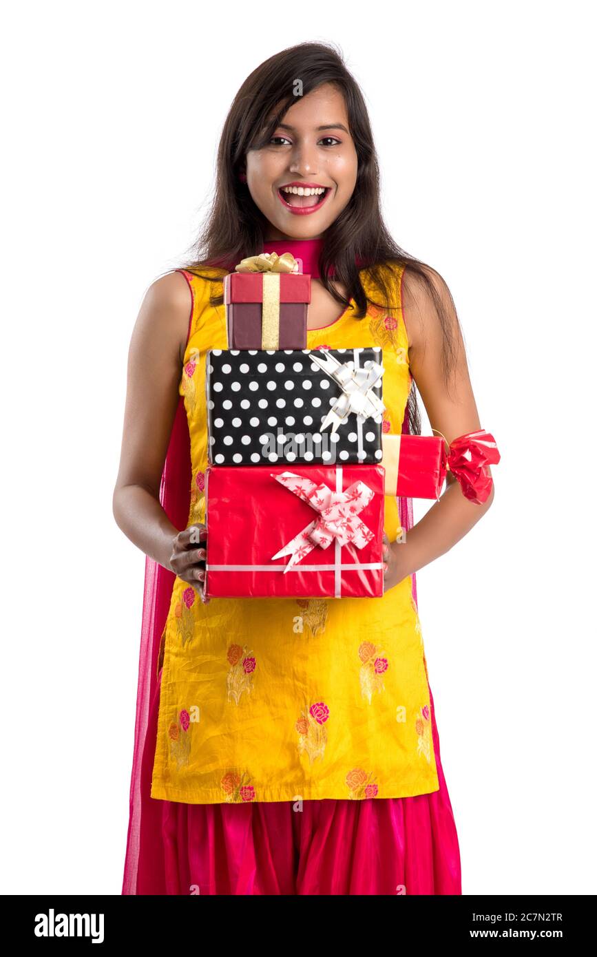 Portrait of young happy smiling Indian Girl holding gift boxes on a ...