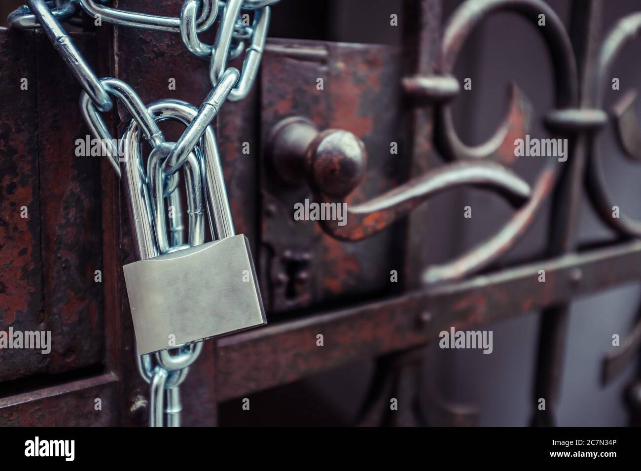 Lock attached to a chain keeping the metal gates closed Stock Photo - Alamy