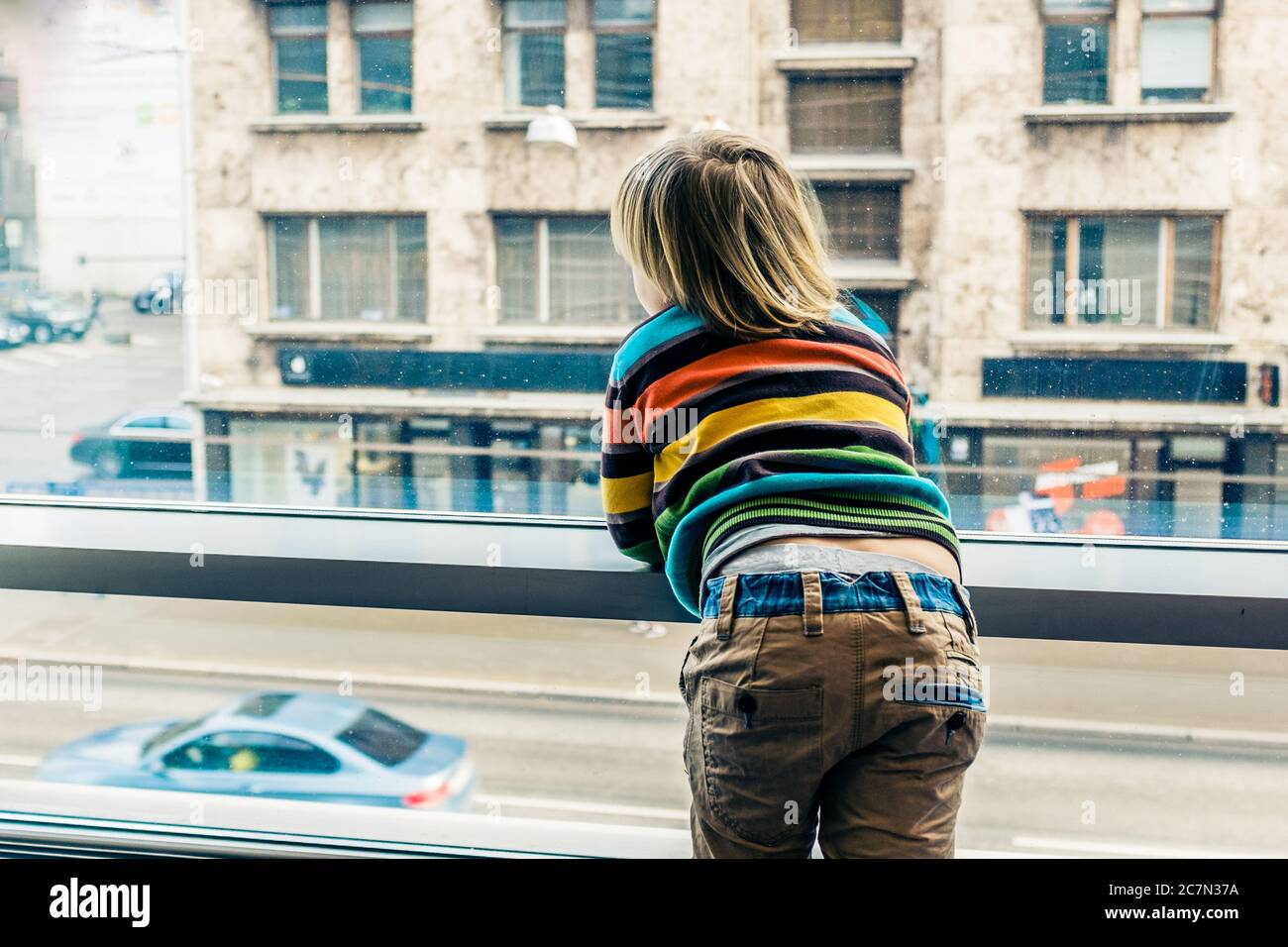 Child looking out of the building in front of another one Stock Photo ...