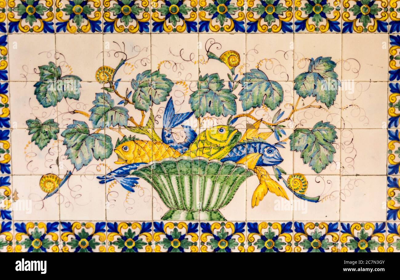 An exquisite piece of tile work featuring a pot filled with fish and a ...