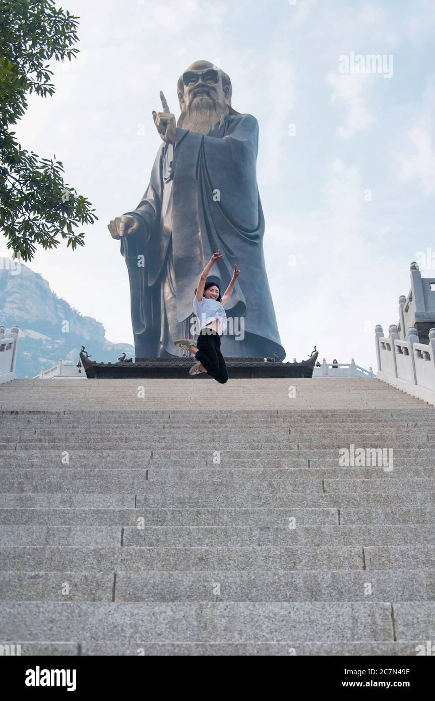 A chinese woman having fun and jumping on the stairs leading up to ...