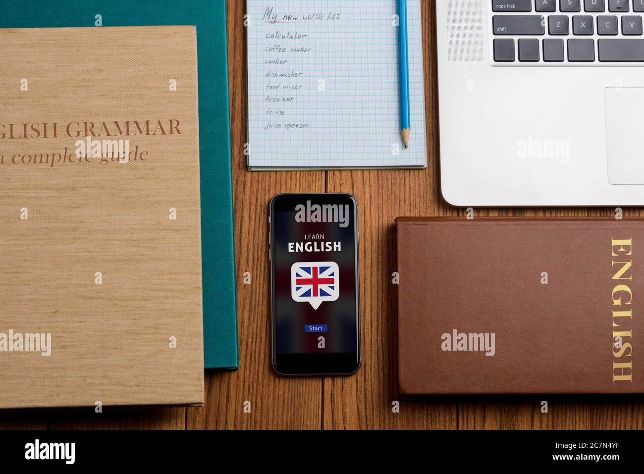 Books and phone on table. Using mobile app to expand vocabulary Stock ...