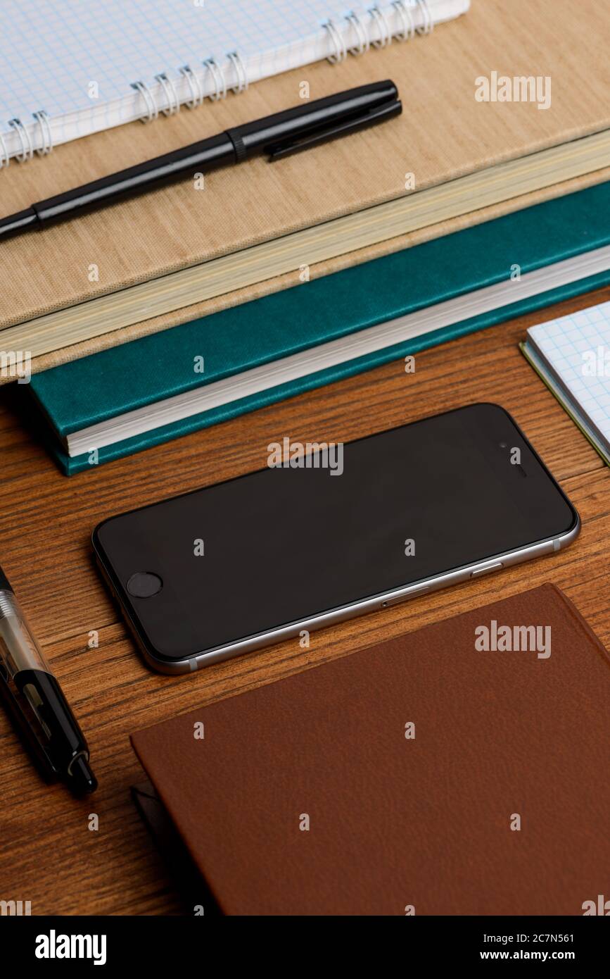 Books and phone on table. Elegant black gadget with turned off screen ...