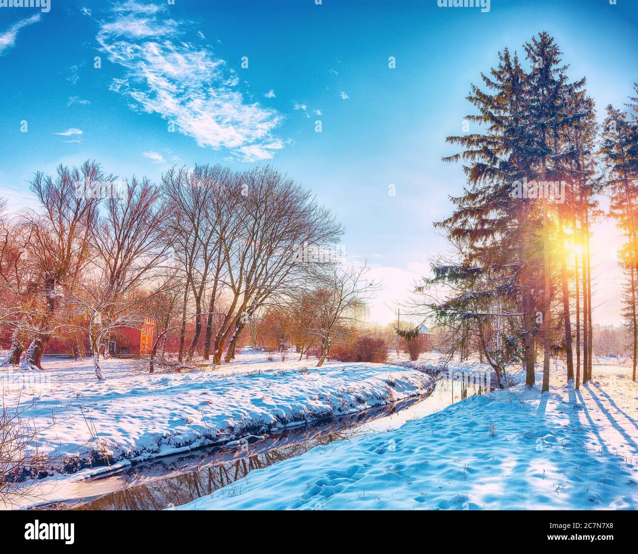 Sunlight breaks through the trees in winter. Lots of snow Stock Photo ...