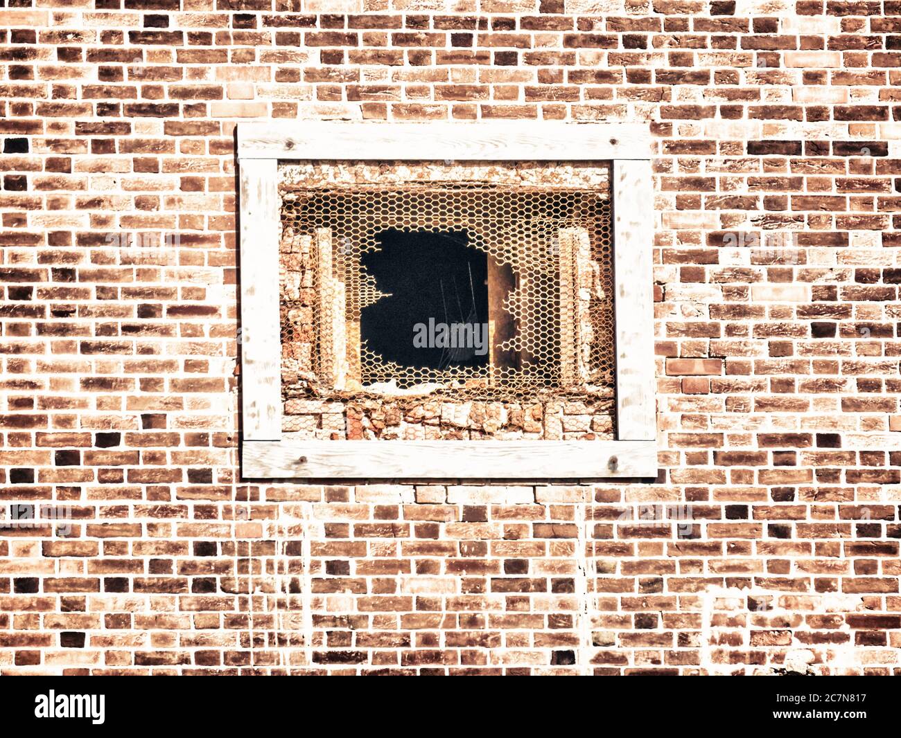 Spider web on a metallic broken and aged window of a brick building ...