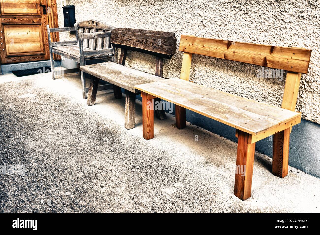 Set of an old, weathered brown benches with patterns on the ground ...