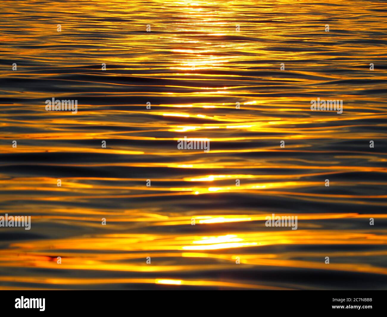 Abstract shot of sunlit orange rippled water Stock Photo - Alamy