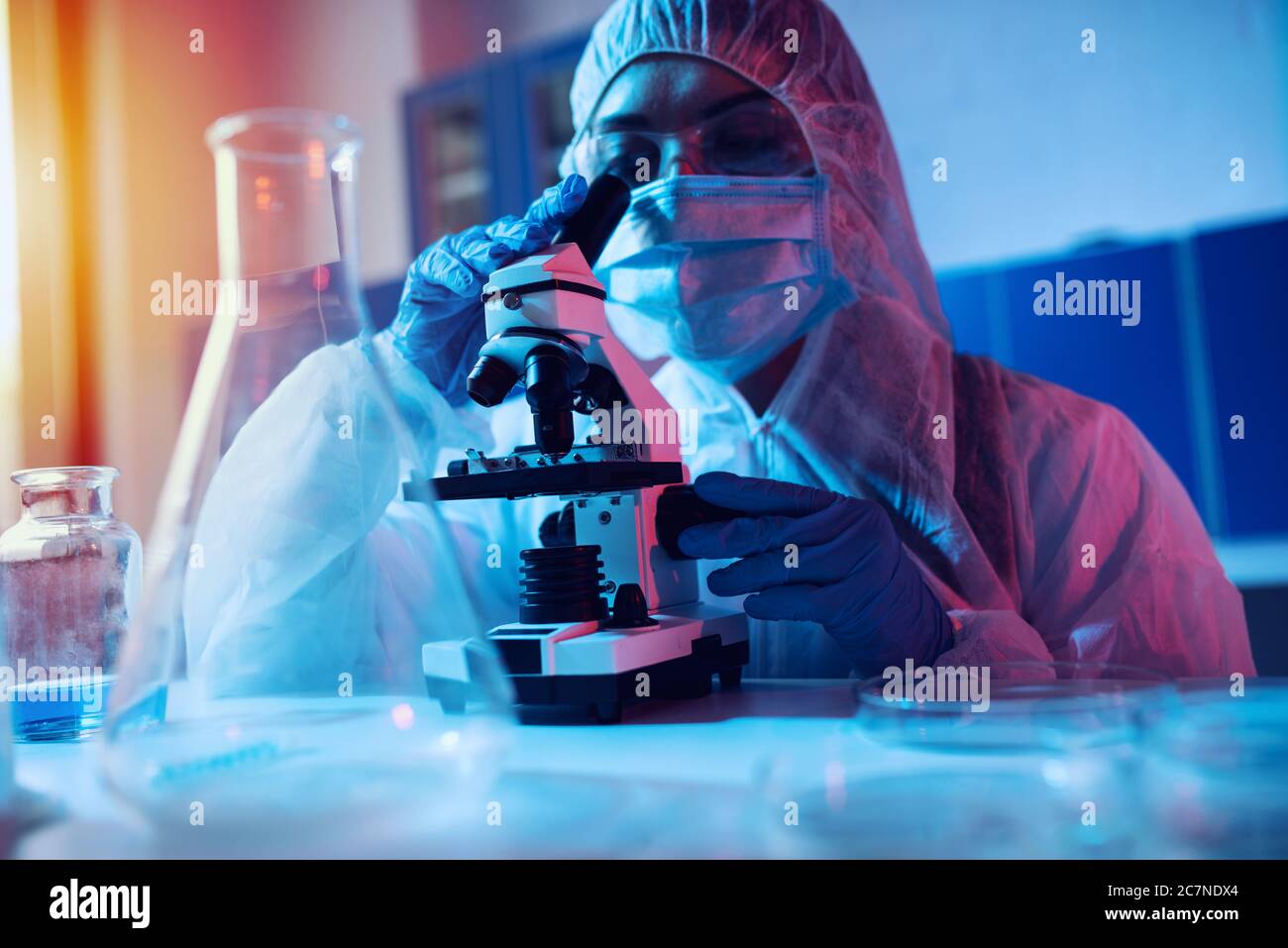 Doctor in the laboratory analyzes samples under a microscope ...