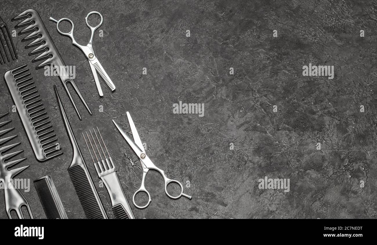 Black combs and combs with scissors on a black background. Copy space ...