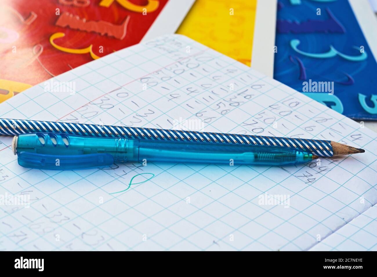 Closeup math exercises written in a textbook with a pen and pencil on ...
