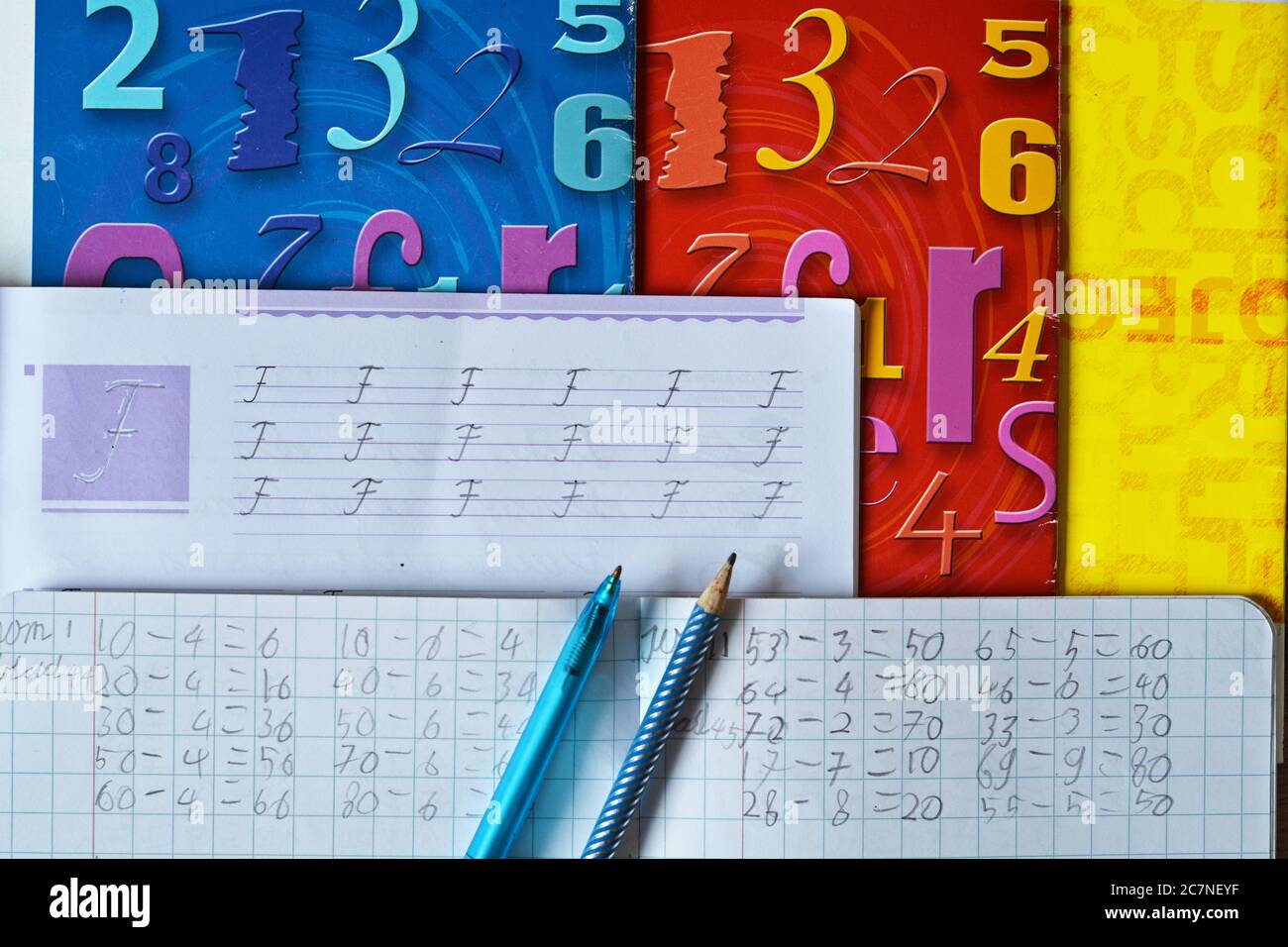 Letters and math exercises written in a textbook with a pen and pencil ...