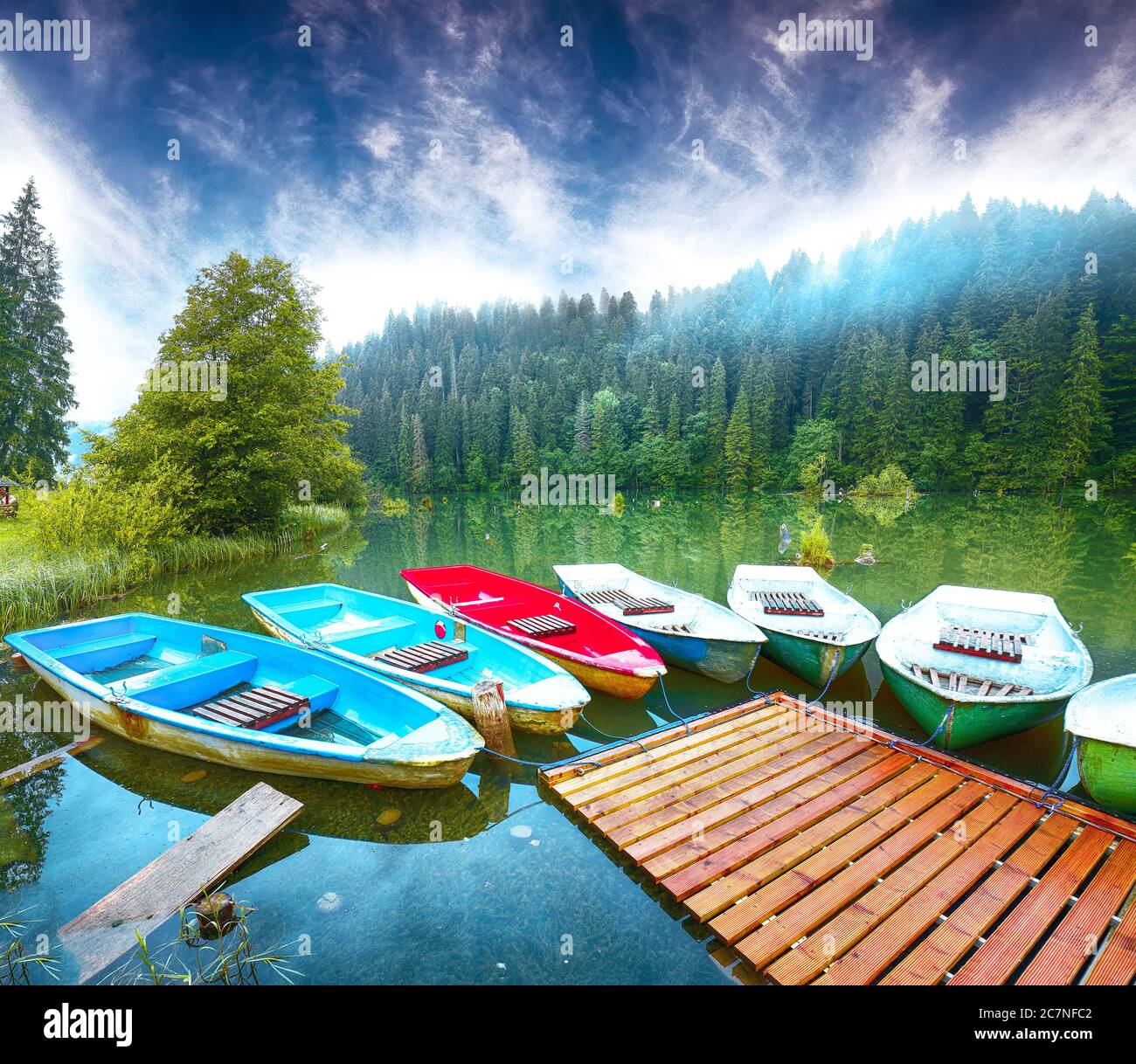 Boats on majestic mountain lake Lacul Rosu or Red Lake or Killer Lake ...