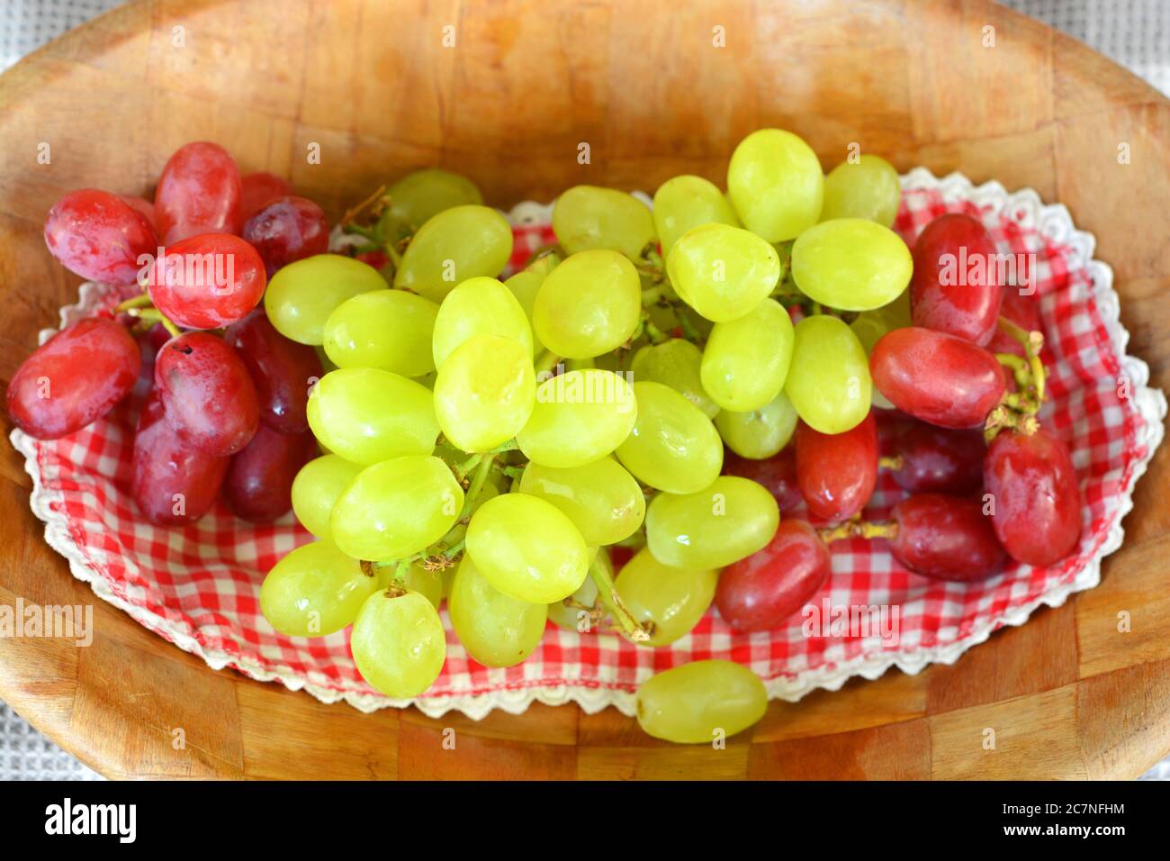 High angle view of red and green grapes on a bowl on the table under ...