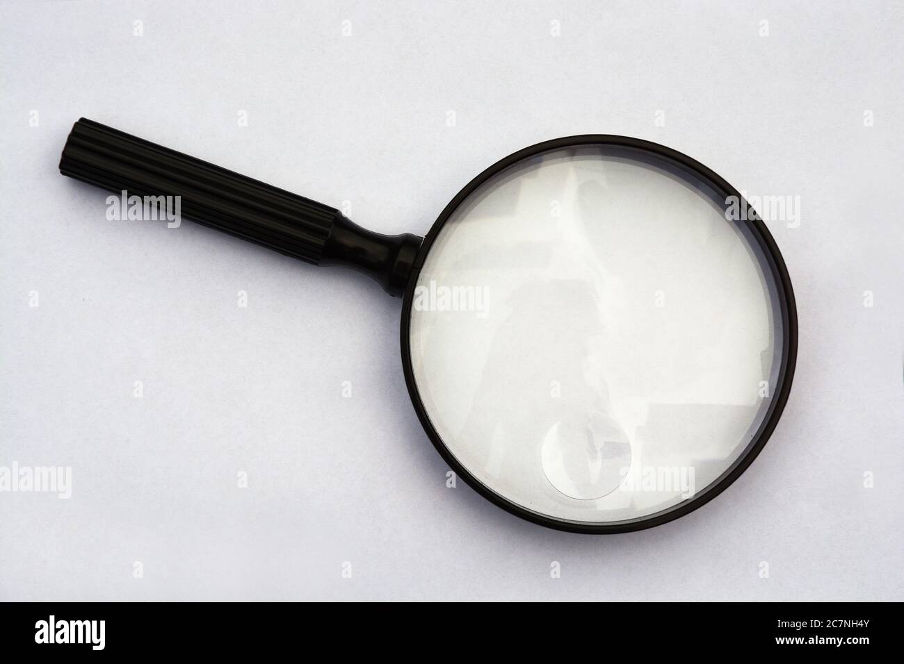 High angle top view isolated closeup shot of a magnifying glass on a ...