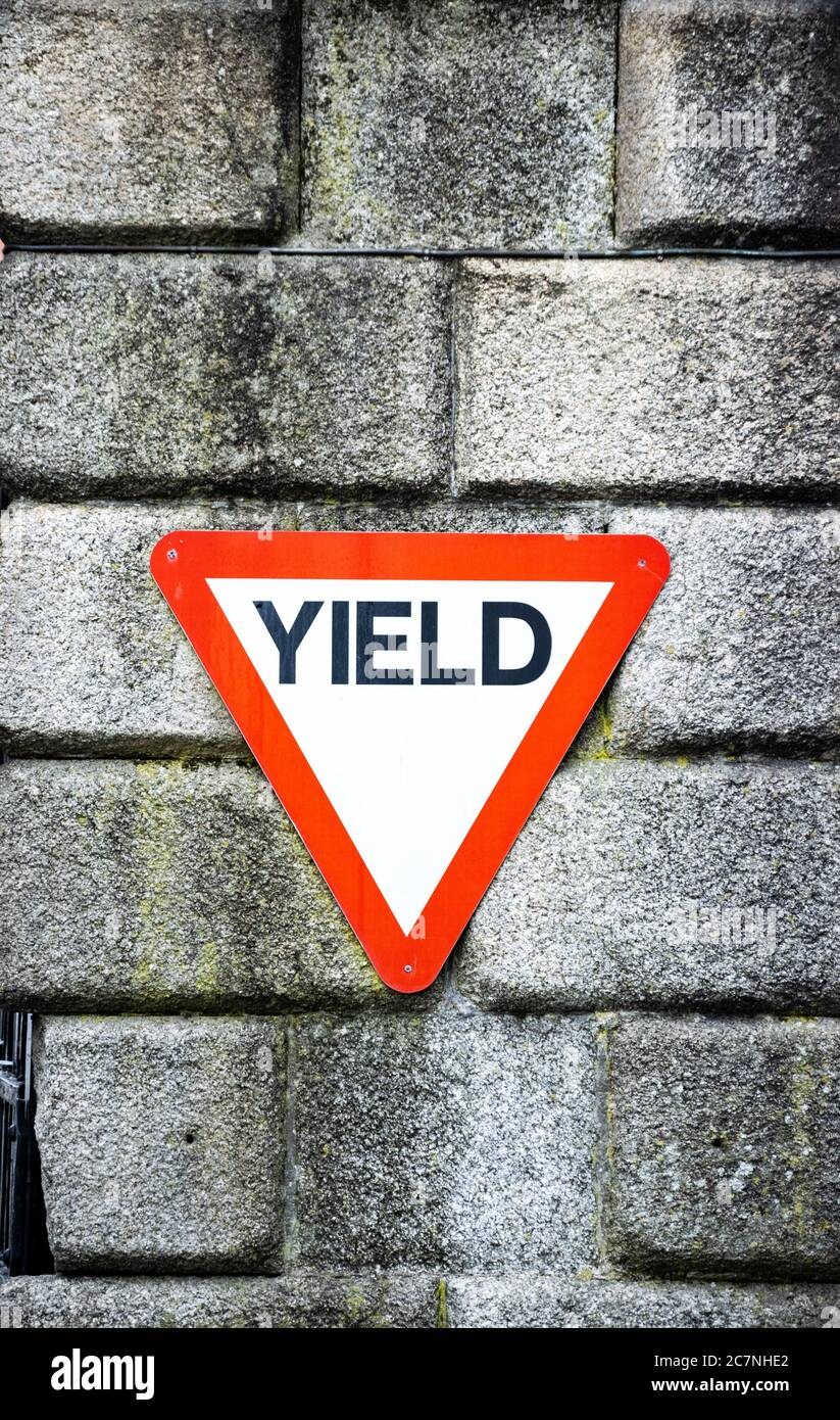 Vertical shot of a yield triangle sign on a wall Stock Photo - Alamy